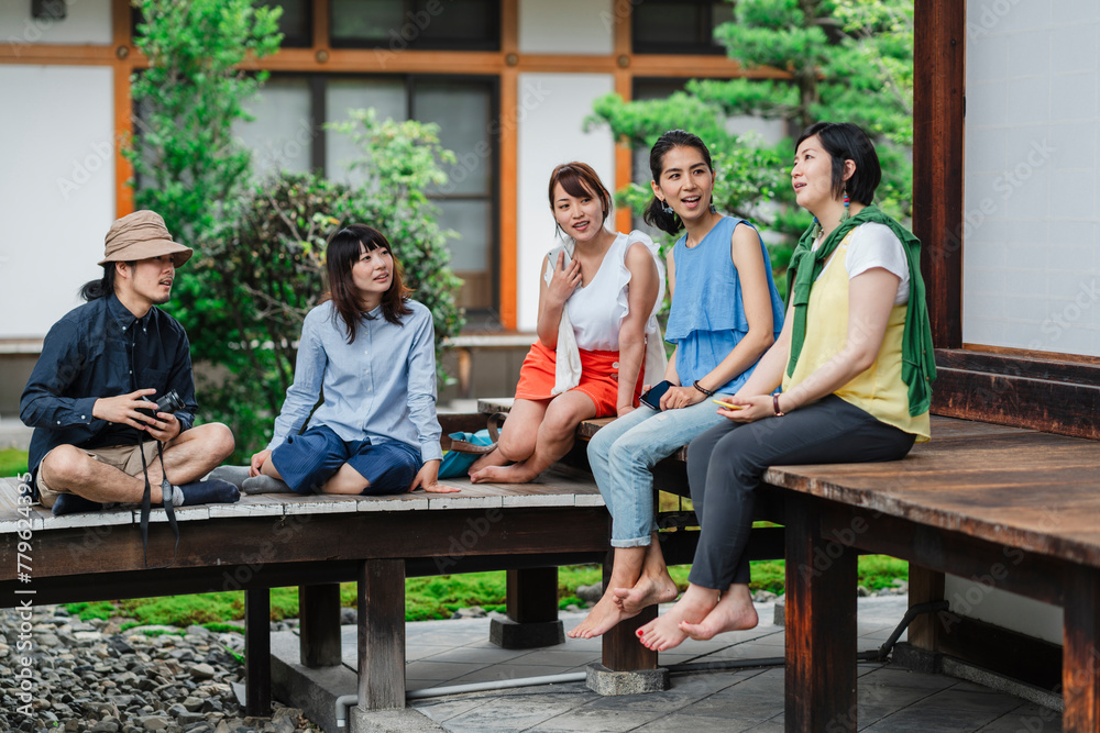 Group of five Japanese friends casually enjoying a conversation on a ...
