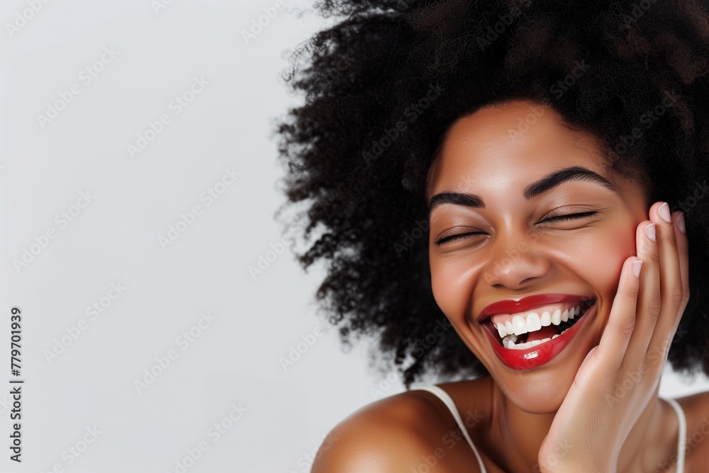 woman laughing with her hands, her head tilted back and eyes closed in ...