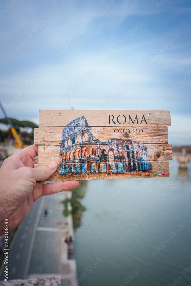 Hand holding Rome Colosseum postcard, designed as wood piece with ROMA ...