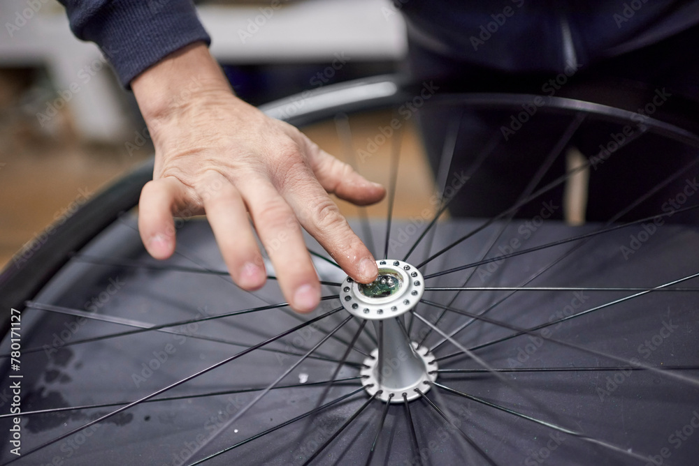 Unrecognizable person greasing the hub of a bicycle wheel, lubricating ...