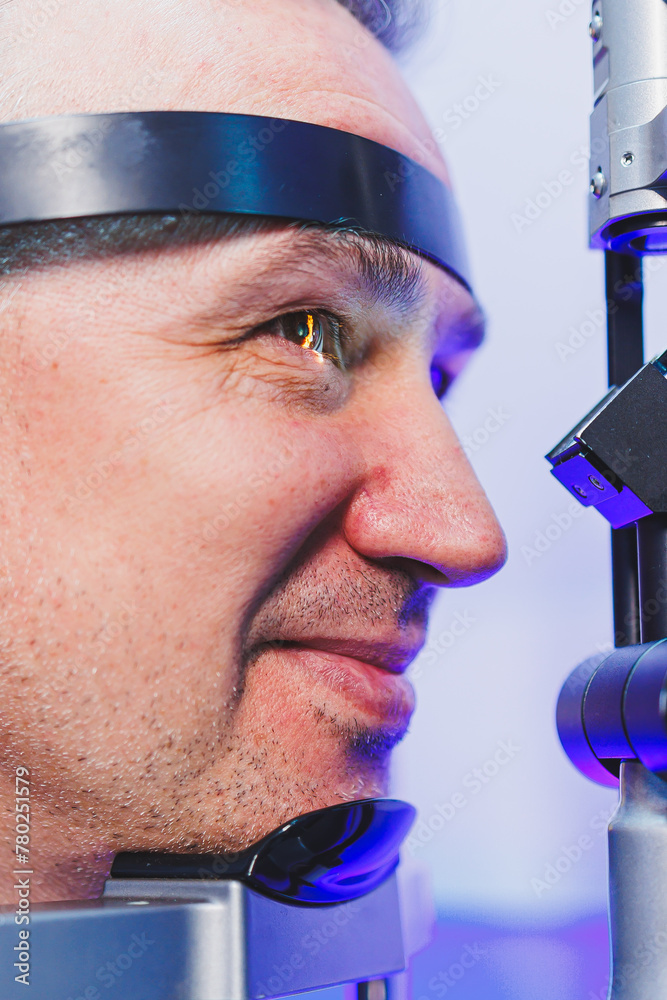 Checking a man's vision with a modern microscope at an appointment with ...