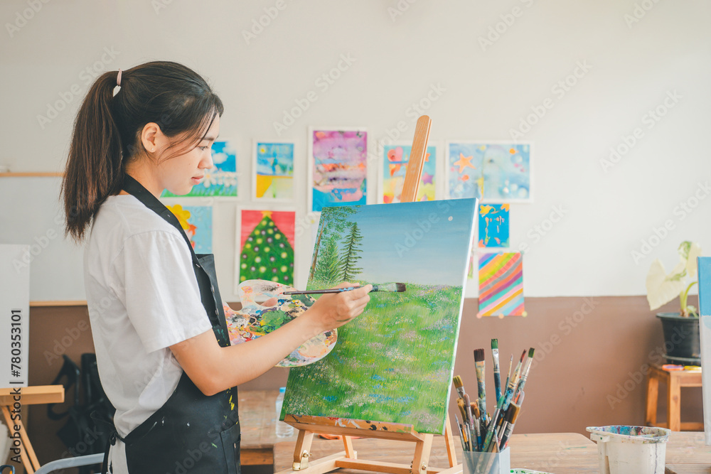 Art student drawing with watercolor painting on canvas doing some art ...