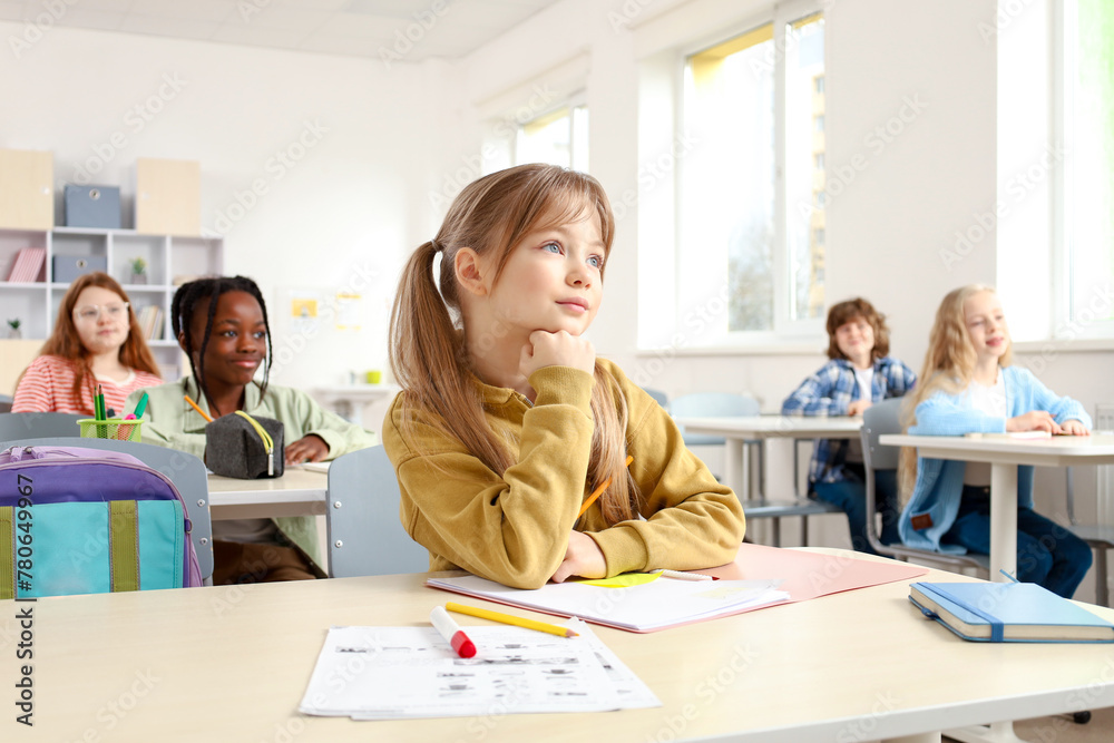 Little girl listening carefully to the teacher while sitting in the ...