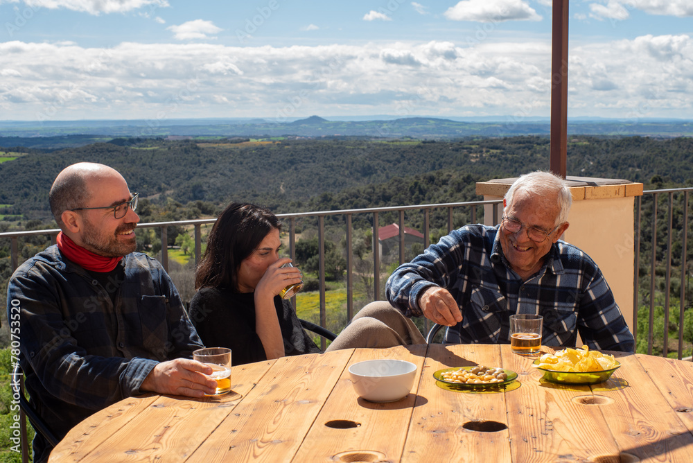 Family in three generations having aperitif on terrace, twenty year old ...