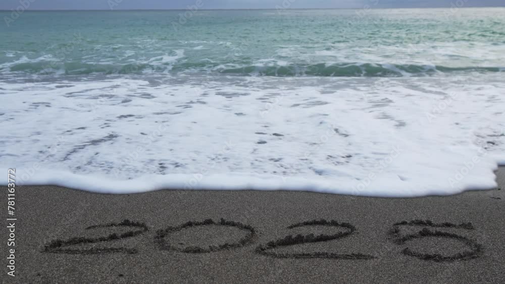Happy New Year 2025 hand written digit 2024 washed by wave on the sea ...