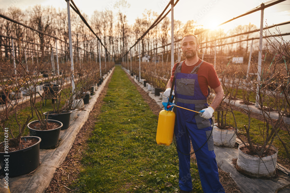 Farmer using pesticide, insecticide and herbicide sprayer sprinkler in ...