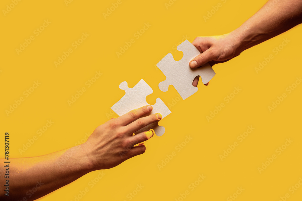 Men holding and putting a piece of jigsaw puzzle together. Two hands ...