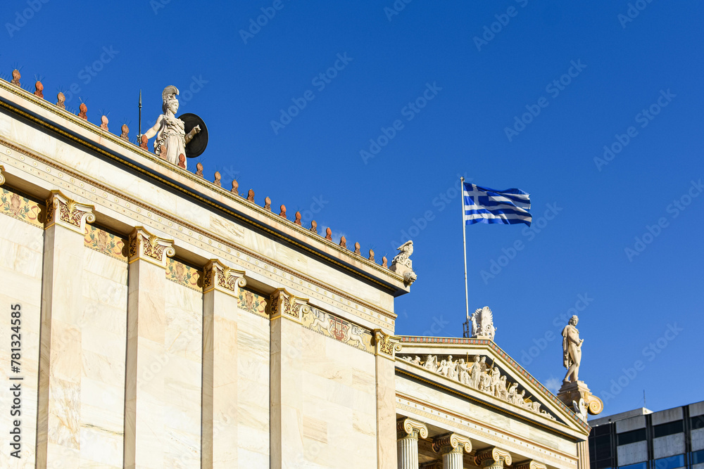 Iconic statue of Athena stands tall beside the Greek flag fluttering ...