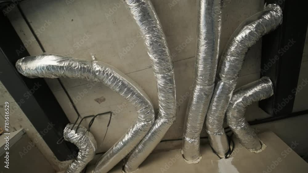 Industrial ceiling with a network of insulated ductwork, showcasing the ...