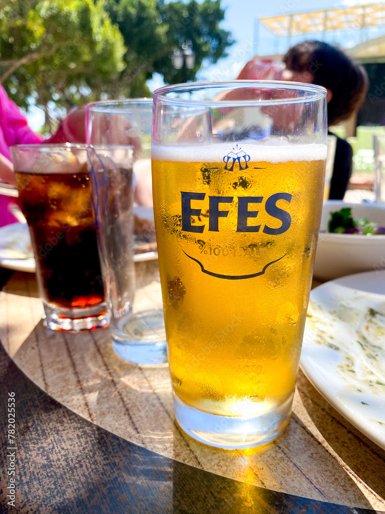 Antalaya, Turkey - April 11 2024: Glass of Efes beer on a table as part ...