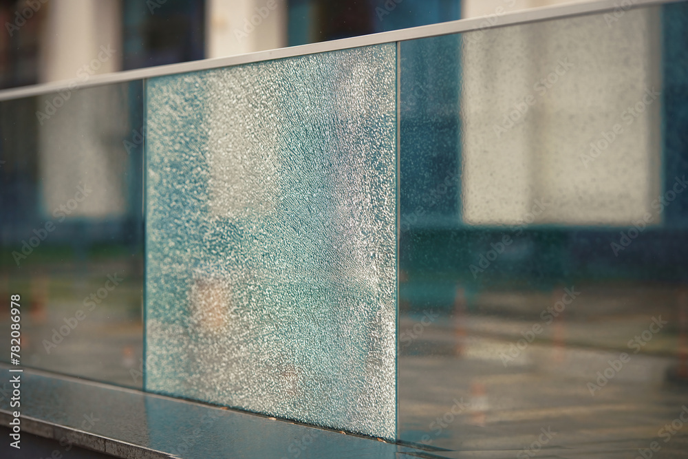 Damaged fence with broken glass, proterty damage. Cracked glass section ...