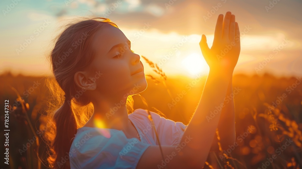 Reaching out to the sun, happy girl at sunset, sunlight shining on her ...