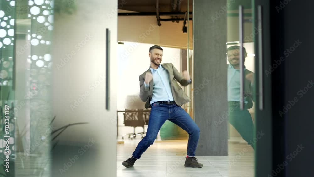 Happy joyful businessman dancing in corridor or hall of modern business ...