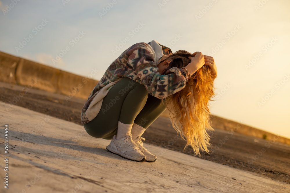 young sad poor woman seating alone at the street stressed and depressed ...