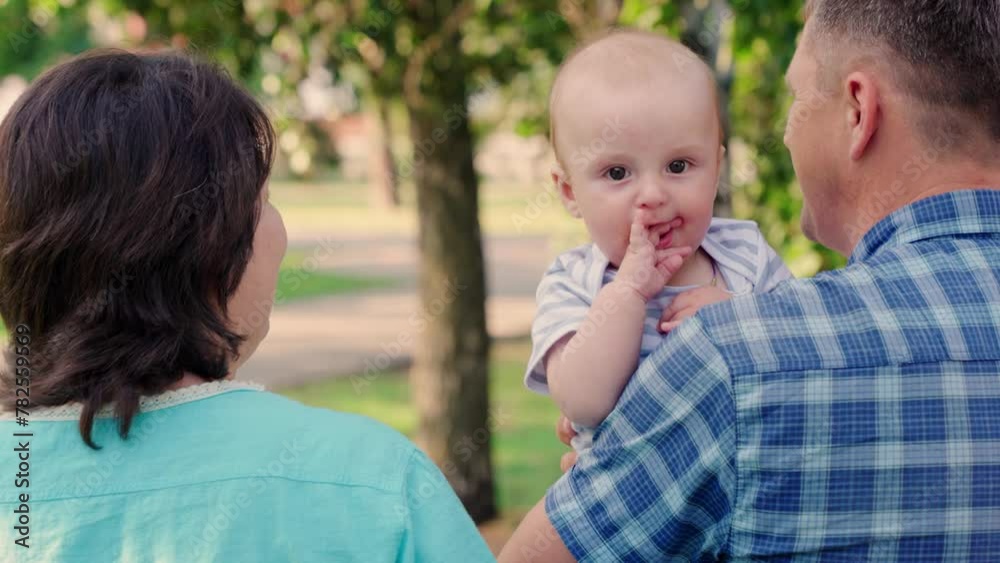 Parents look at child together in park. Dad mom love, care, parenting ...