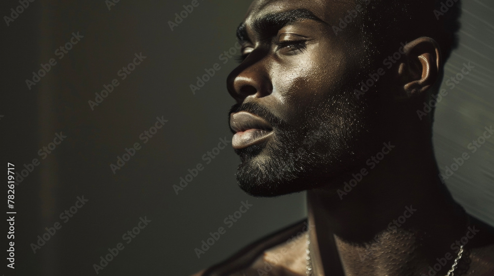 Against a backdrop of dark shadows a confident black man stands tall ...