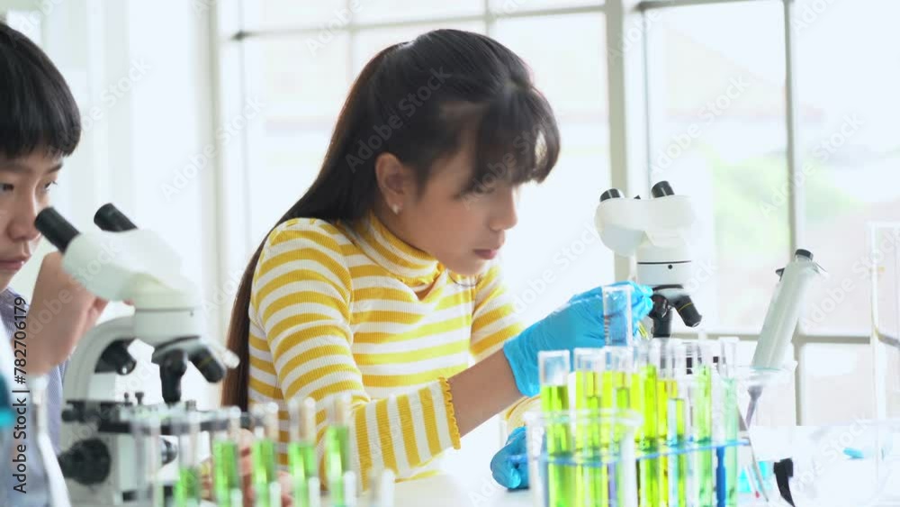 asian schoolgirl pupil student looking through microscope during ...