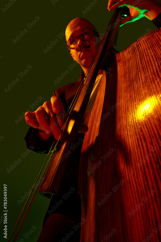 Artistic, talented young bass player performing jazz composition in red ...