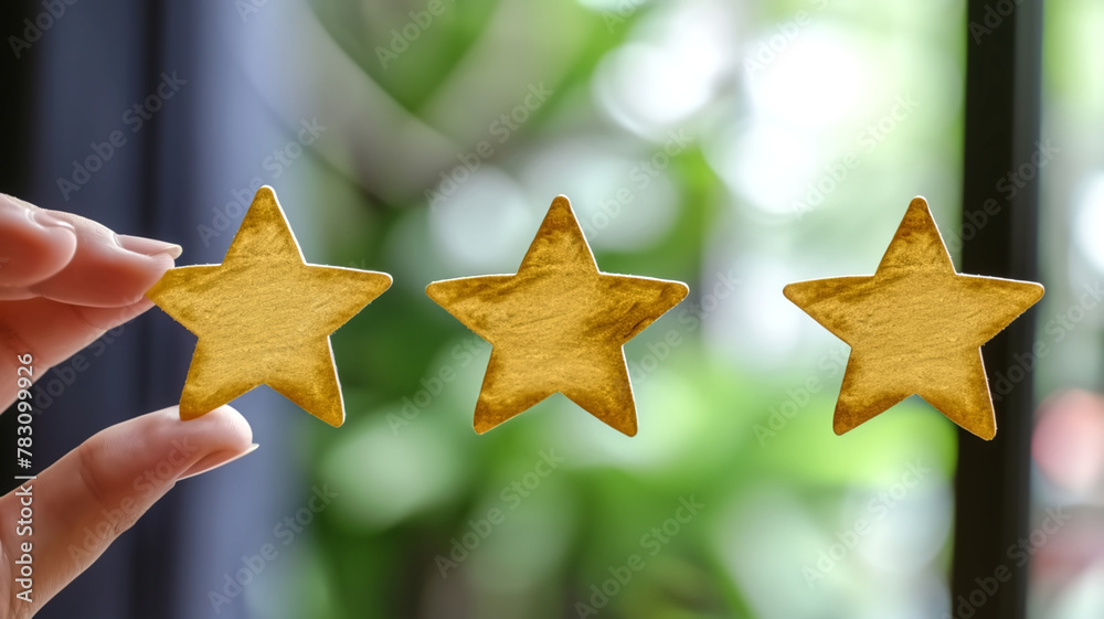 Hand holding a golden star with two others in alignment. Rating and ...