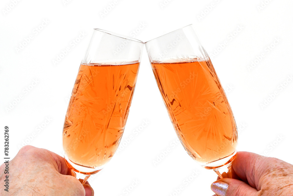Two people raising a celebratory toast with two cut glass crystal flute ...