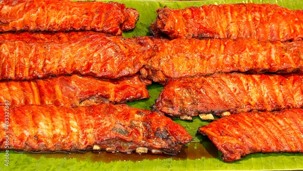 Sizzling pork belly strips on a banana leaf display the allure of Asian ...