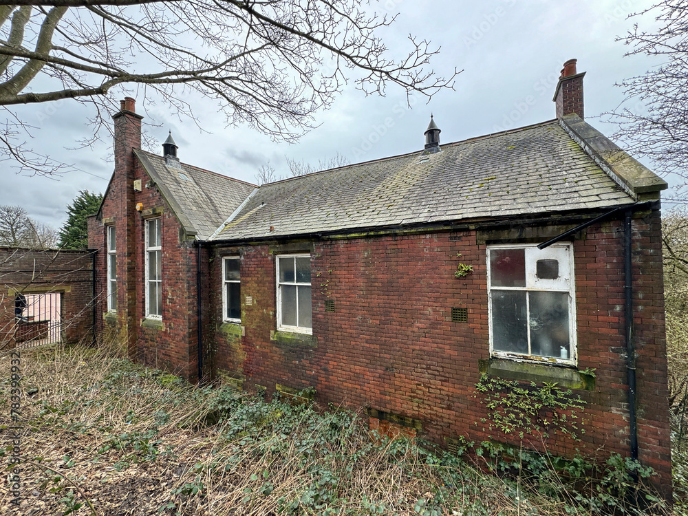 An abandoned late Victorian red brick building with several pitched ...