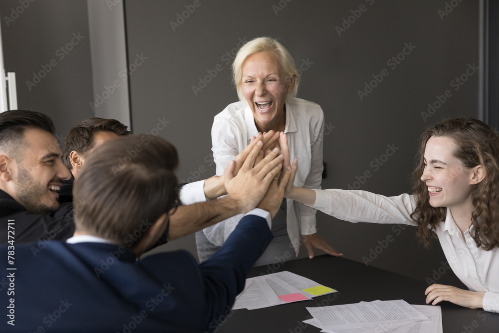 Happy team stack their hands together, showing unity, giving support ...
