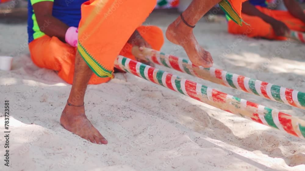 Close up shot of legs of local men dancing with wooden sticks on beach ...