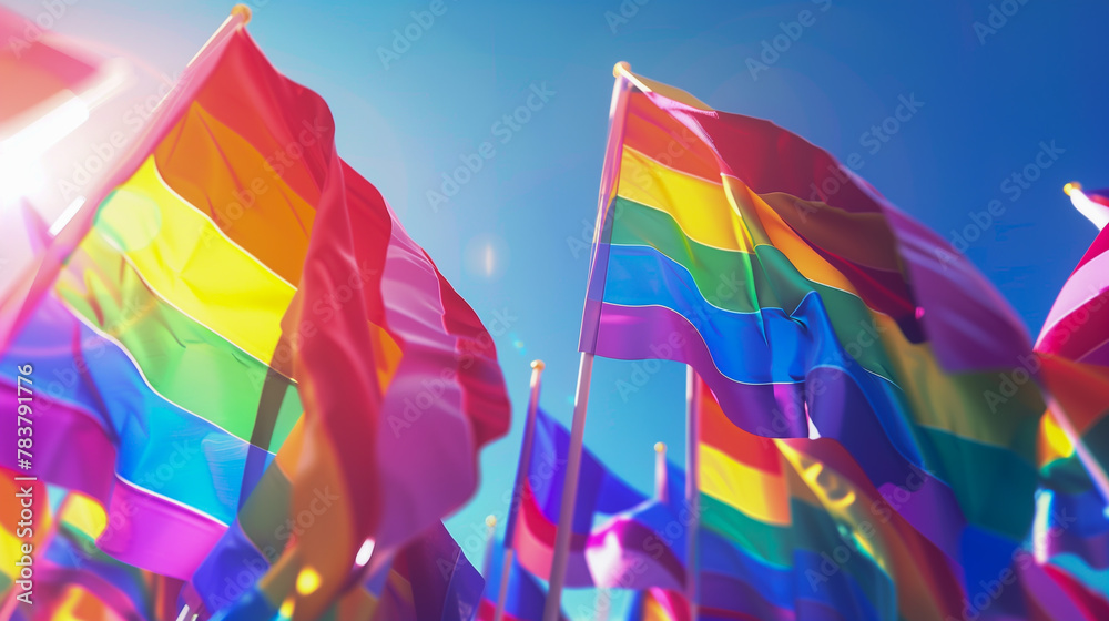 Pride Month, Multiple pride flags waving under a clear blue sky ...
