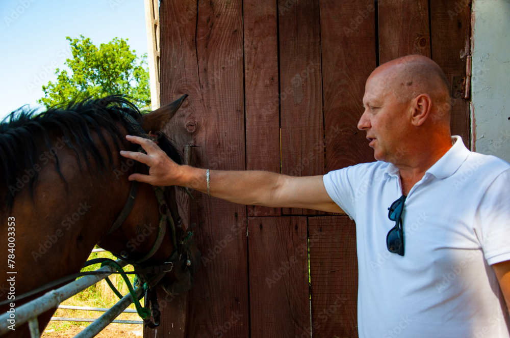Man with horse in stable at countryside ranch. Man horse rider in ...