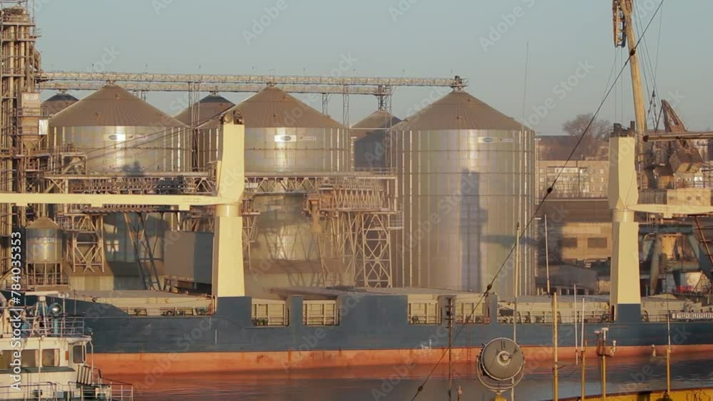 Bulk carrier ship docks at grain silo terminal for loading. Conveyor ...