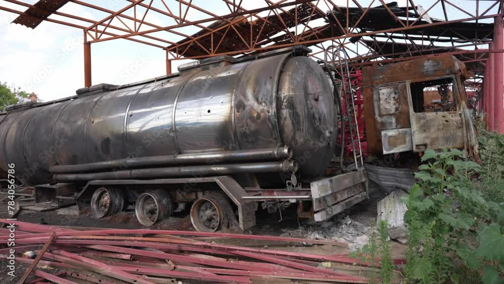Remains of tank from trailer in damaged hangar. Large metal tank from ...