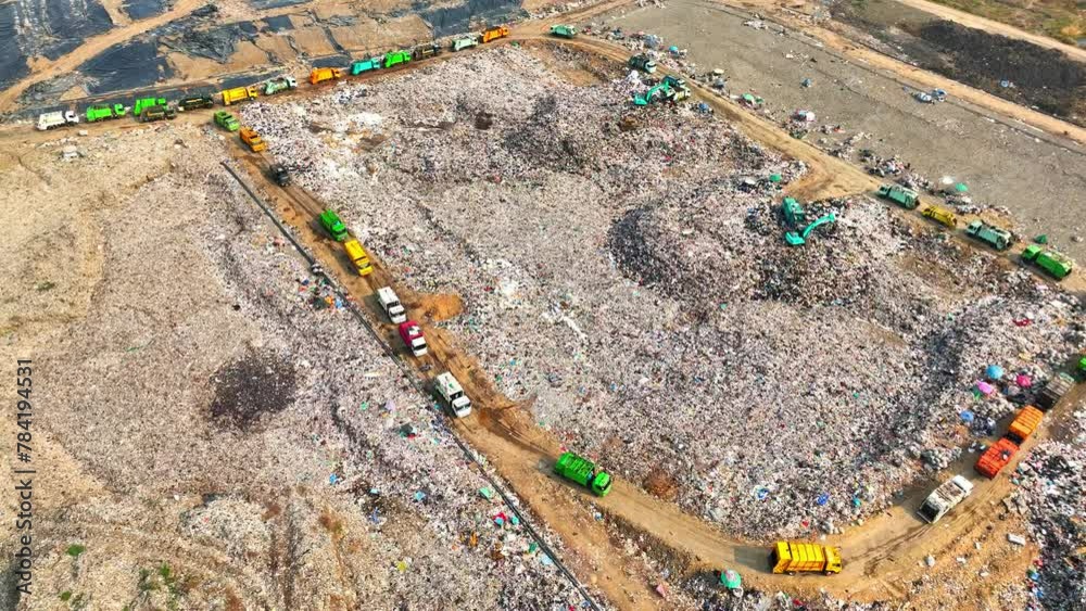 A discarded items blankets the landfill, crisscrossed by dusty roads ...