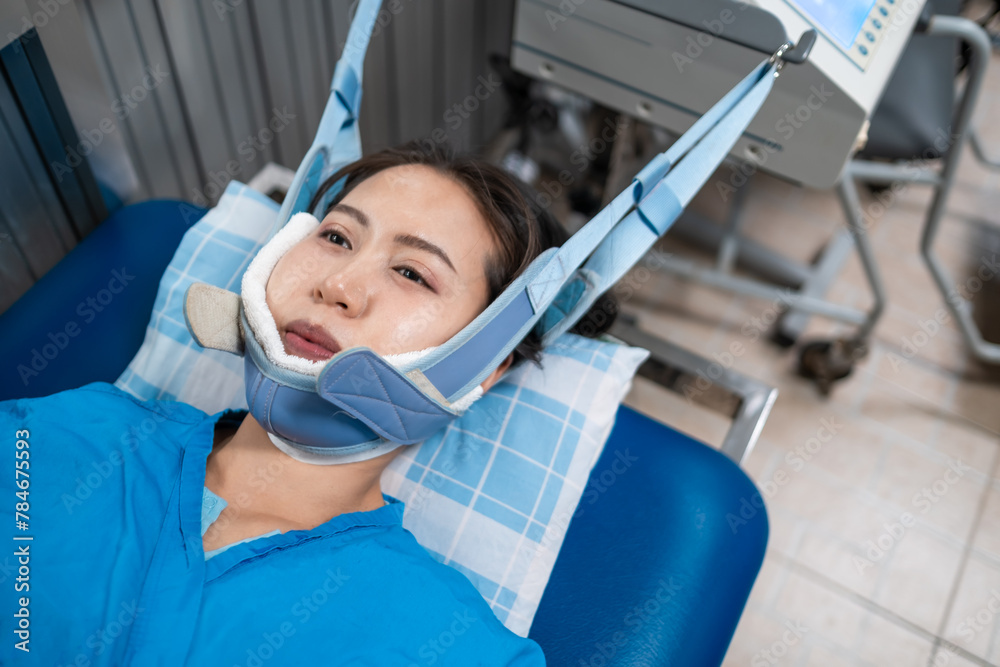 Top view of female patient under cervical traction machine pulling the ...