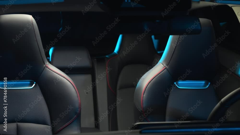 The camera slowly moves around the black interior of a premium car. The ...