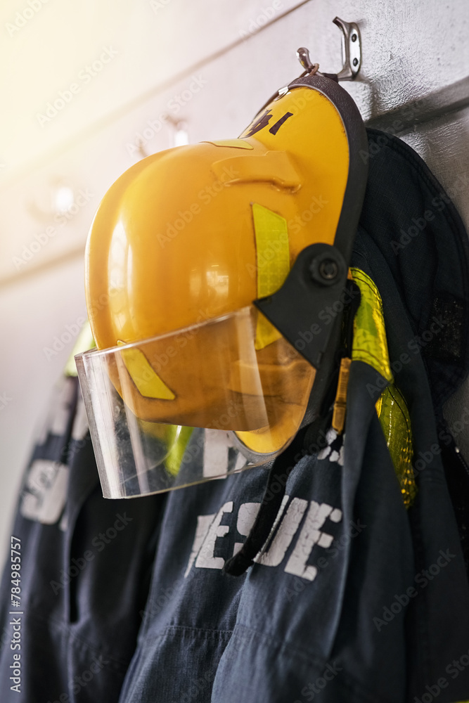 Uniform, helmet and jacket of firefighter on wall for rescue, emergency ...