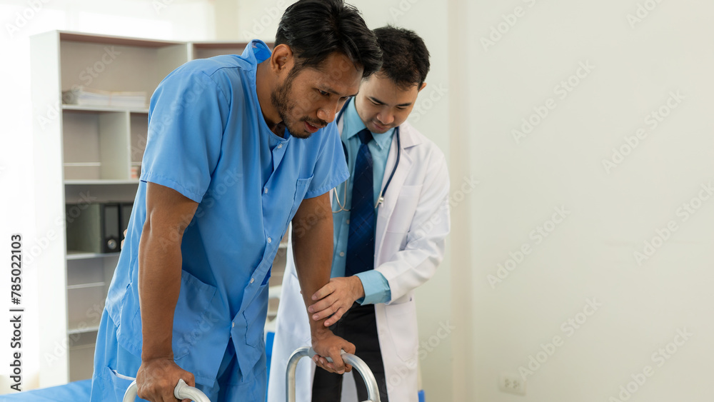 Physical therapist helping a patient while stretching his legs on a bed ...