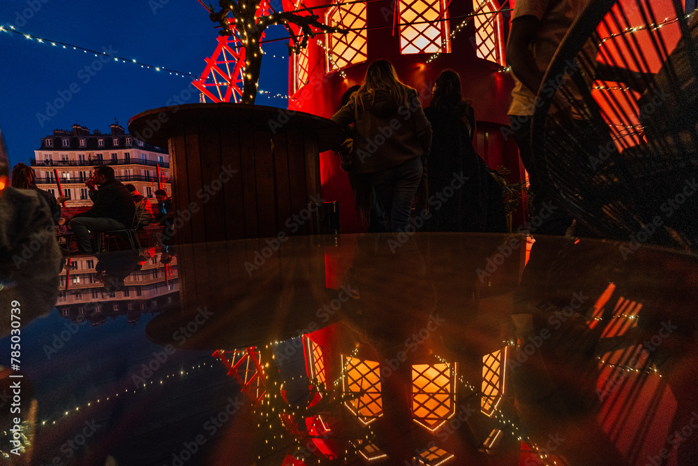 Moulin Rouge at night with lights during French sunset. Spinning moulin ...
