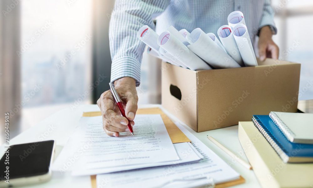 Asian men packing roll of personal documents into a box reading and ...