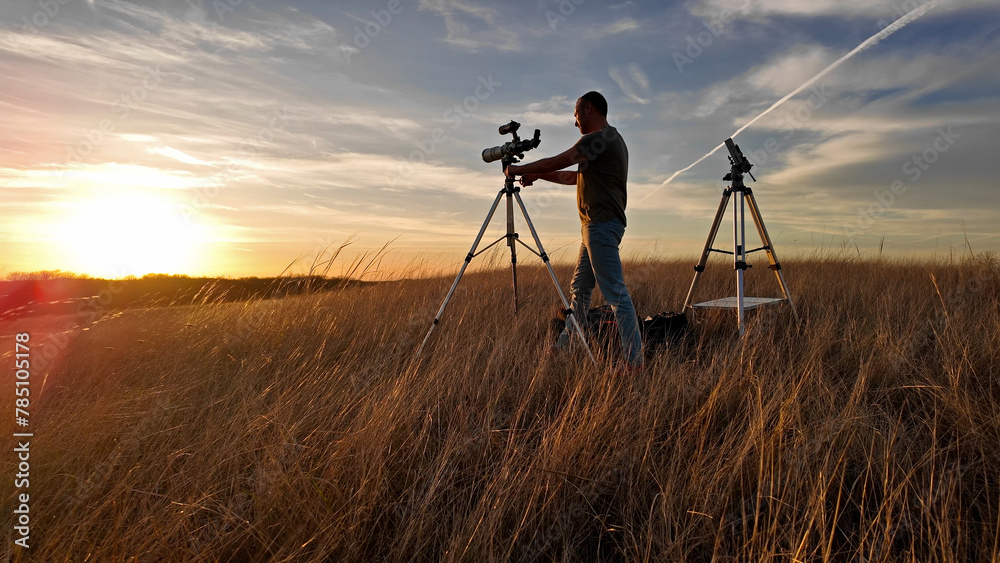 Amateur astronomer observing Solar eclipse and Sun with a telescope and ...