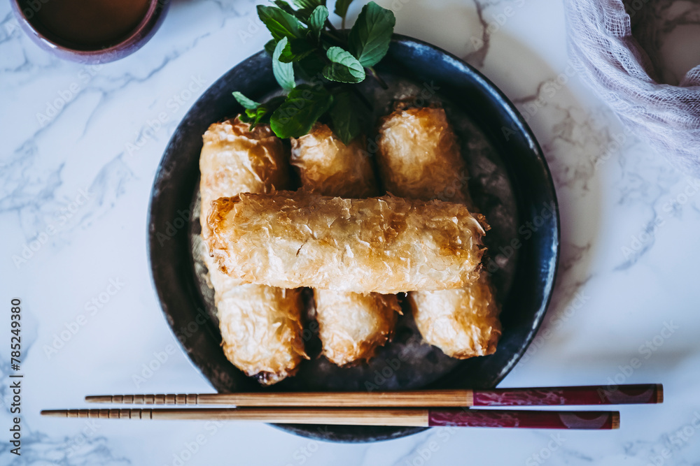 Nems au poulet accompagné de sauce piquante et feuilles de salade et ...