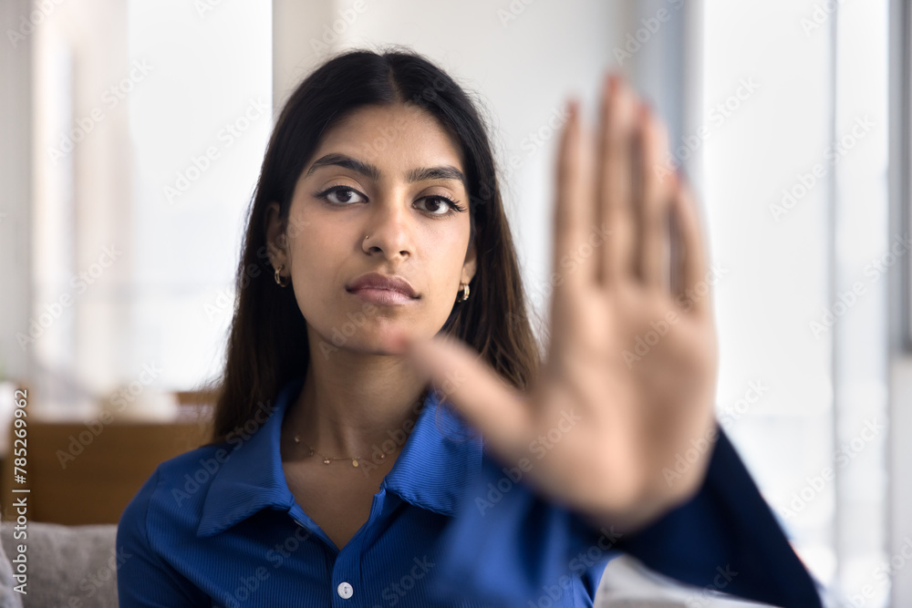 Serious determined young Indian woman showing stop symbol, open palm at ...
