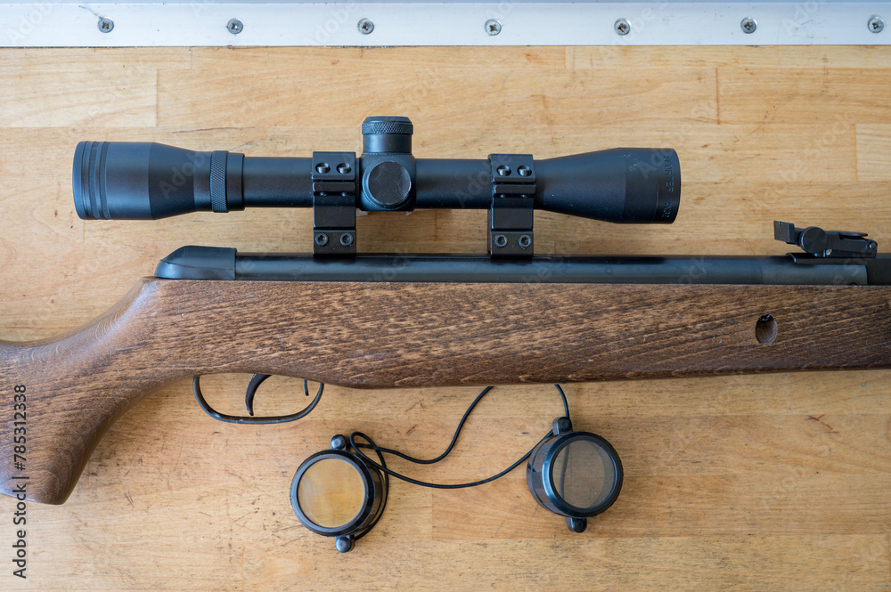 Detail of a light precision air rifle with optical sight on a wooden ...