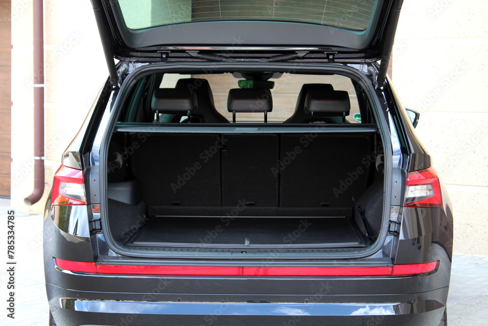 The car is ready to load luggage. Modern black SUV open trunk. Clean trunk SUV car. Open back ...