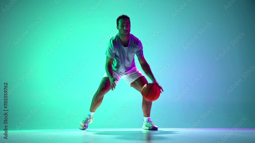 Young man, focused basketball player in motion, showing skills in ball ...