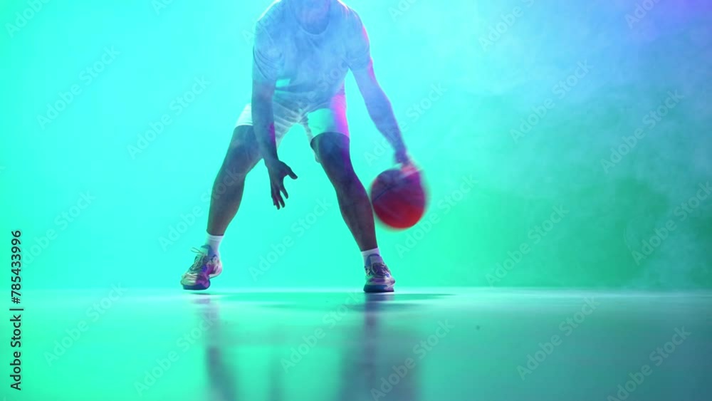 Male basketball player in motion, training, coordinating ball in ...