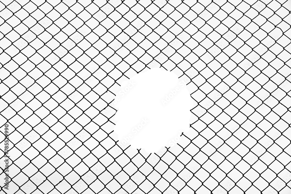 Opening in metallic fence against a blue sky with white clouds ...