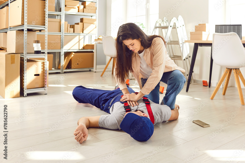 Young woman giving first aid to Injured unconscious worker lying on the ...