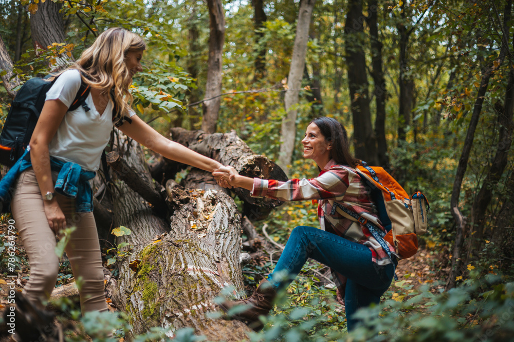 Group Of Female Friends With Backpacks Helping Each Other On Hike ...