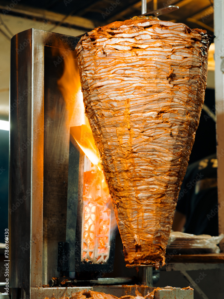Vertical image Grilling traditional trompo al pastor street taco pork ...